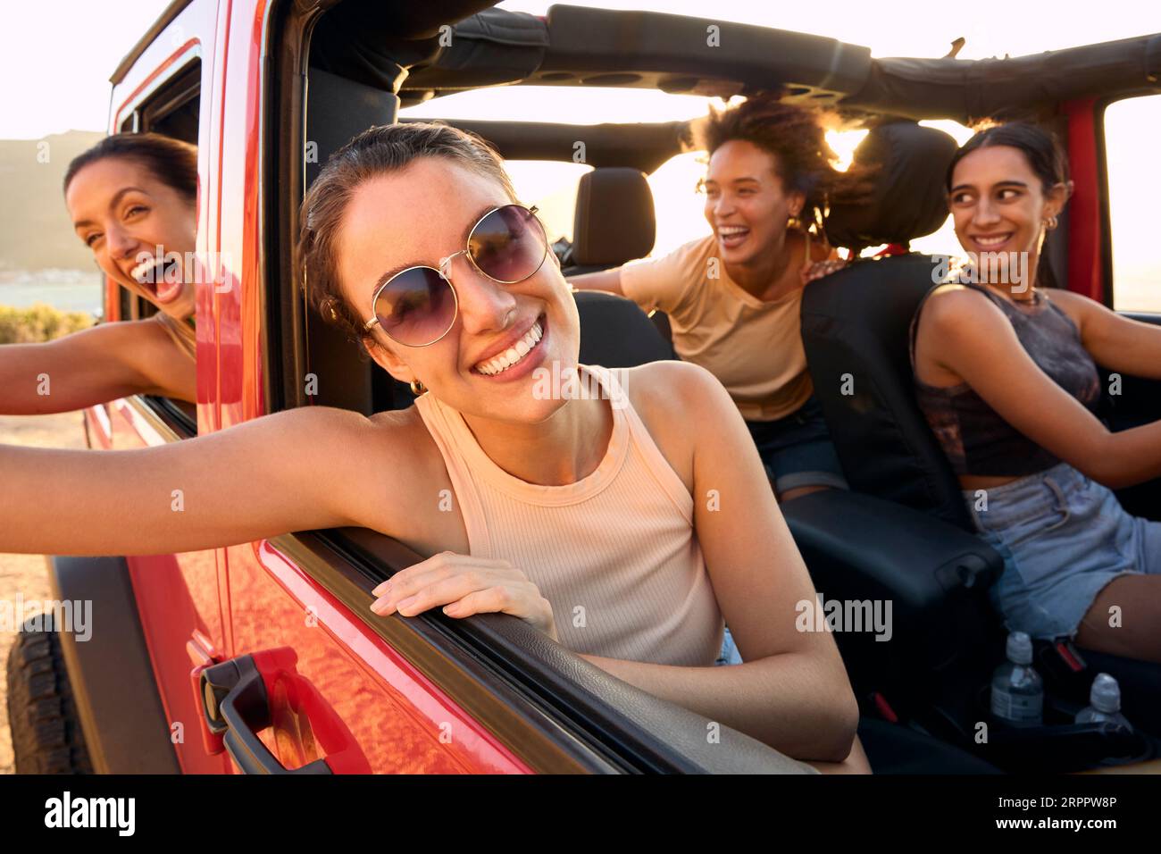 Portrait Of Laughing Female Friends Having Fun In Open Top Car On Road ...