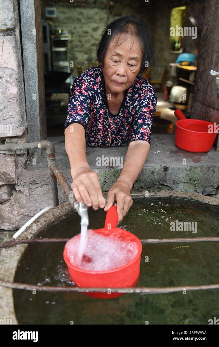 200322 -- NANNING, March 22, 2020 -- A villager takes tap water through ...