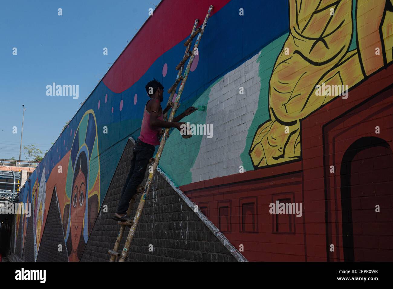 New Delhi, Delhi, India. 5th Sep, 2023. An artist paints a wall mural ...