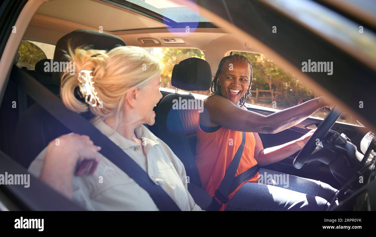 Two Senior Female Friends Enjoying Day Trip Out Driving In Car Together ...
