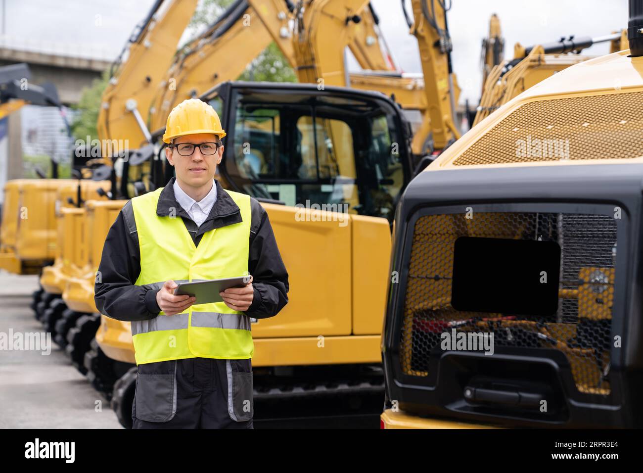 Engineer in a helmet with a digital tablet stands next to construction ...