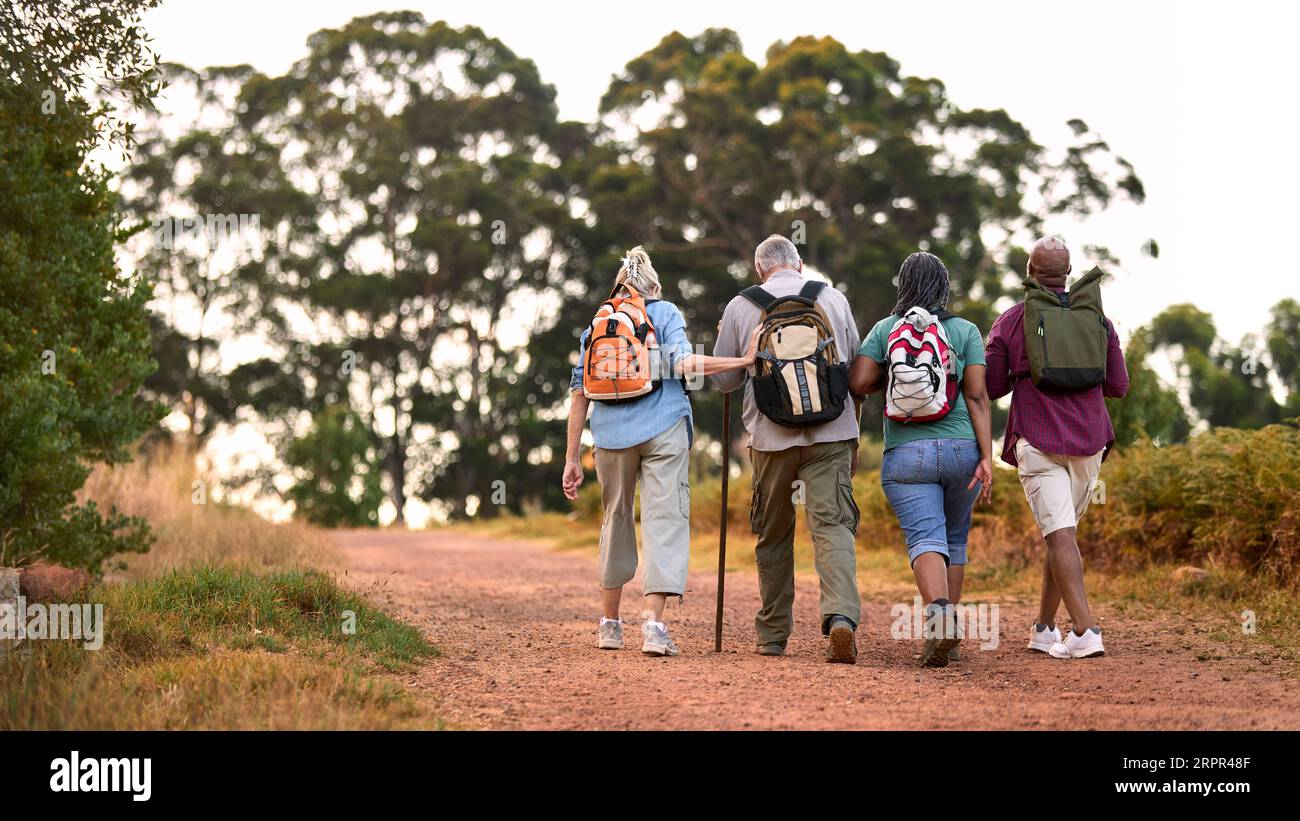 Rear View Of Active Senior Friends Enjoying Hiking Through Countryside ...