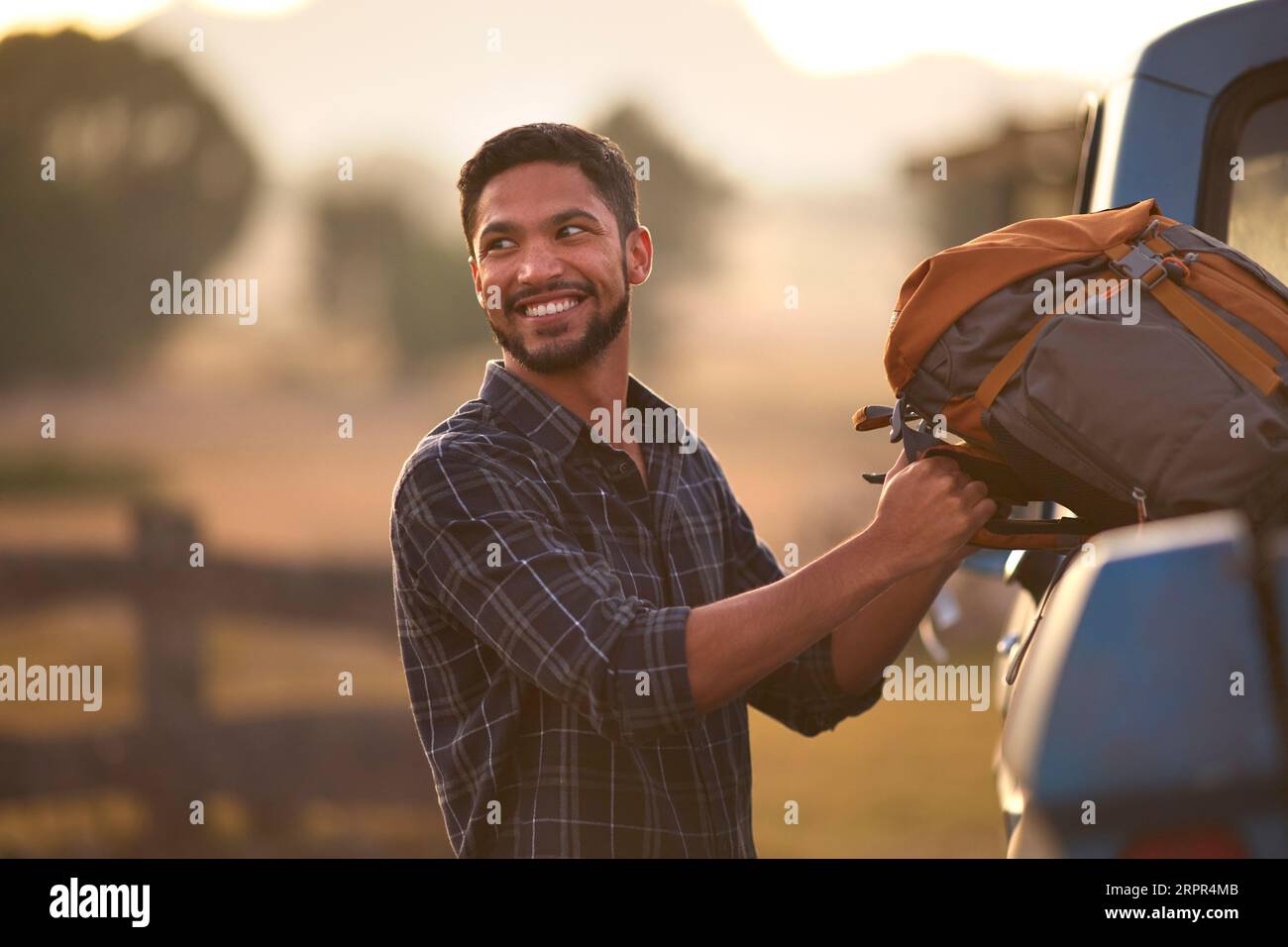 Man Loading Backpack Into Pick Up Truck For Road Trip To Cabin In ...