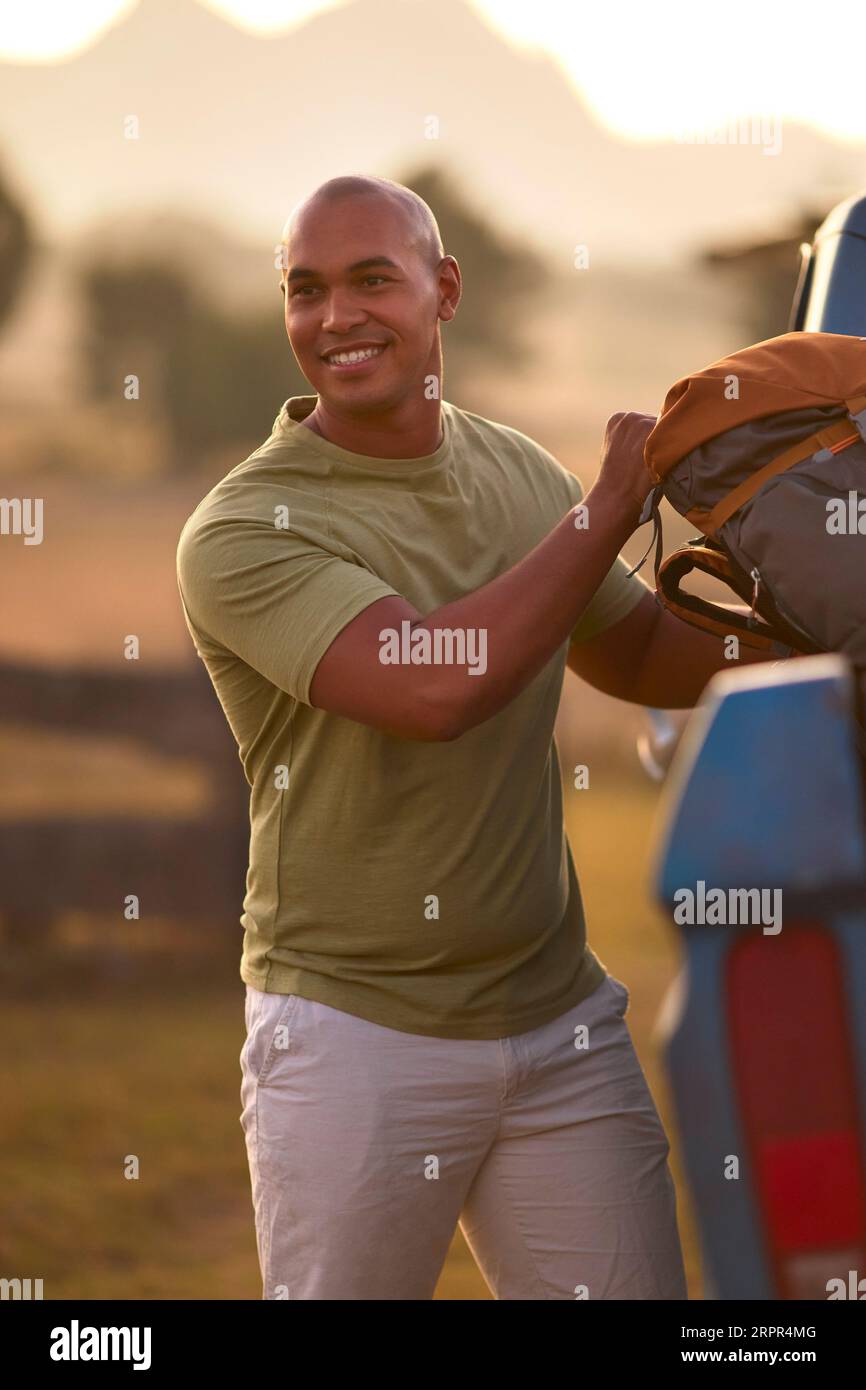 Man Loading Backpack Into Pick Up Truck For Road Trip To Cabin In ...