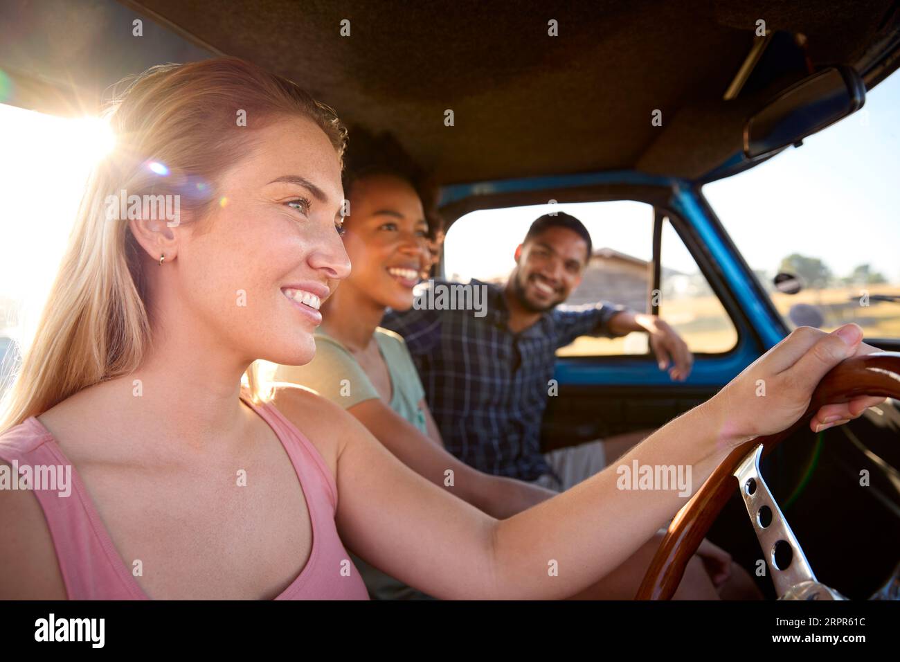 Group Of Friends On Road Trip Driving In Cab Of Pick Up Truck Stock ...