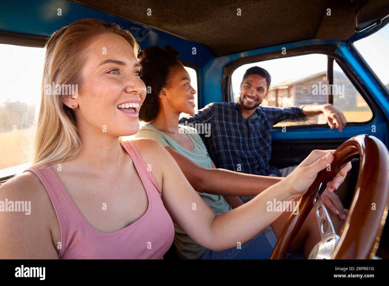 Group Of Friends On Road Trip Driving In Cab Of Pick Up Truck Stock ...