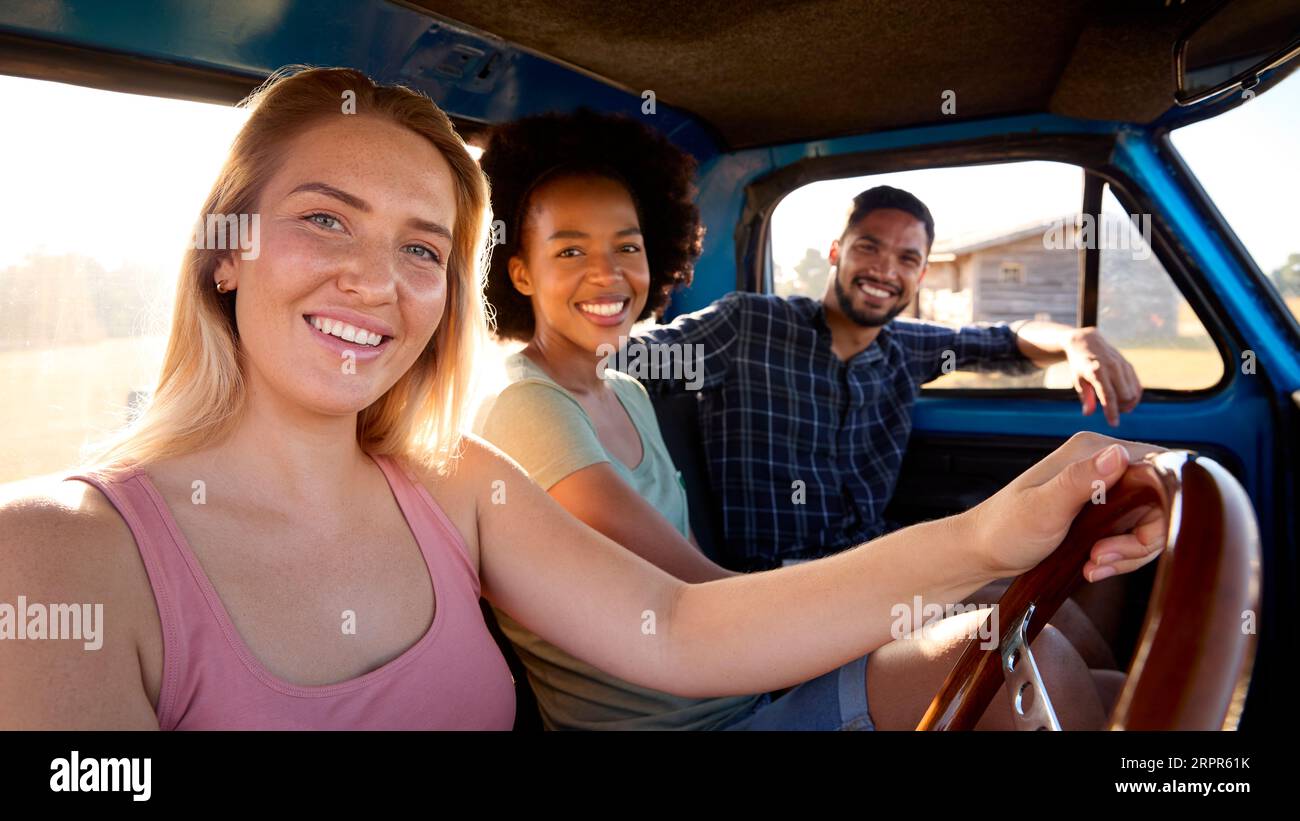 Portrait Of Group Of Friends On Road Trip Driving In Cab Of Pick Up ...