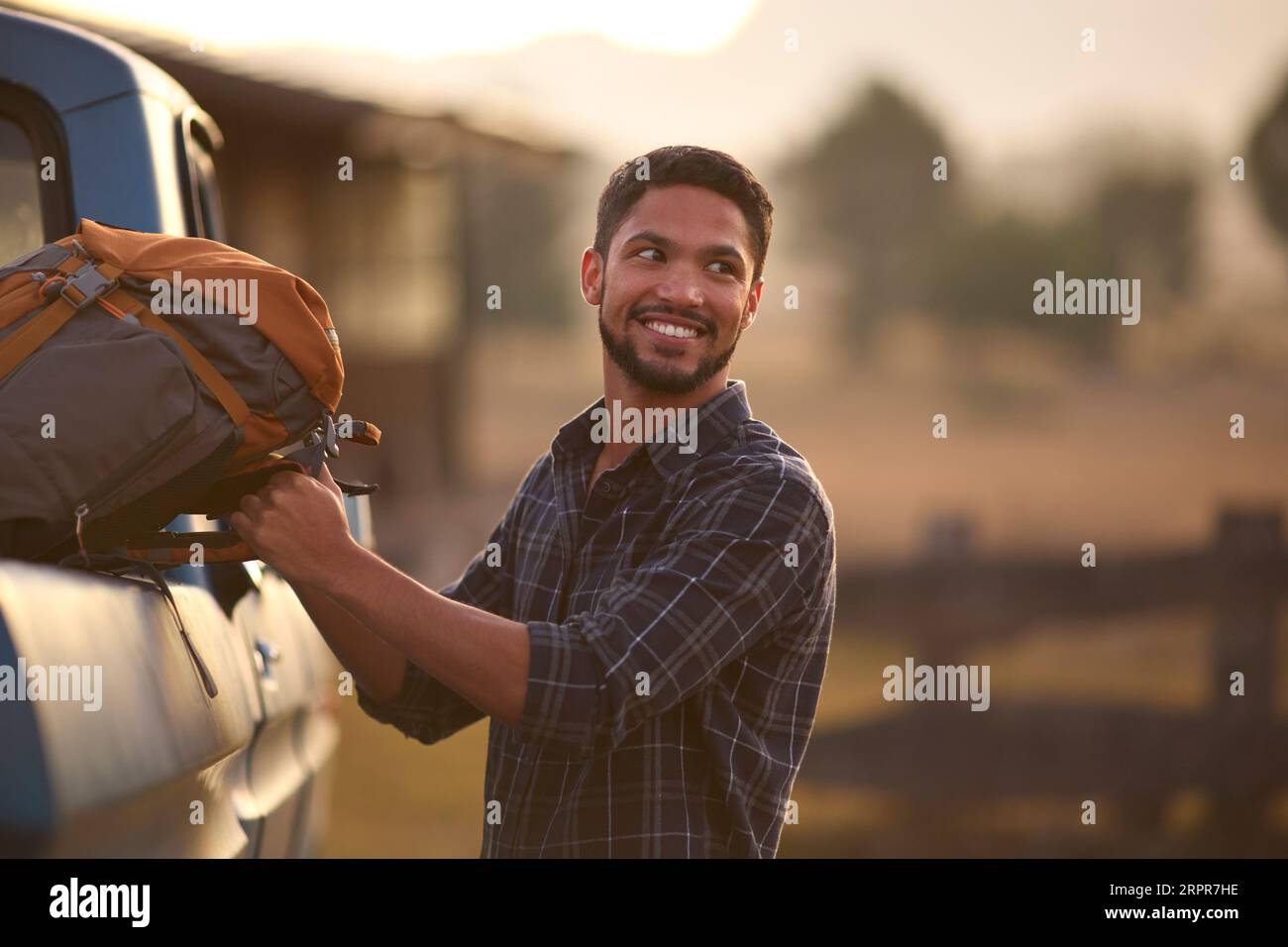 Man Loading Backpack Into Pick Up Truck For Road Trip To Cabin In ...