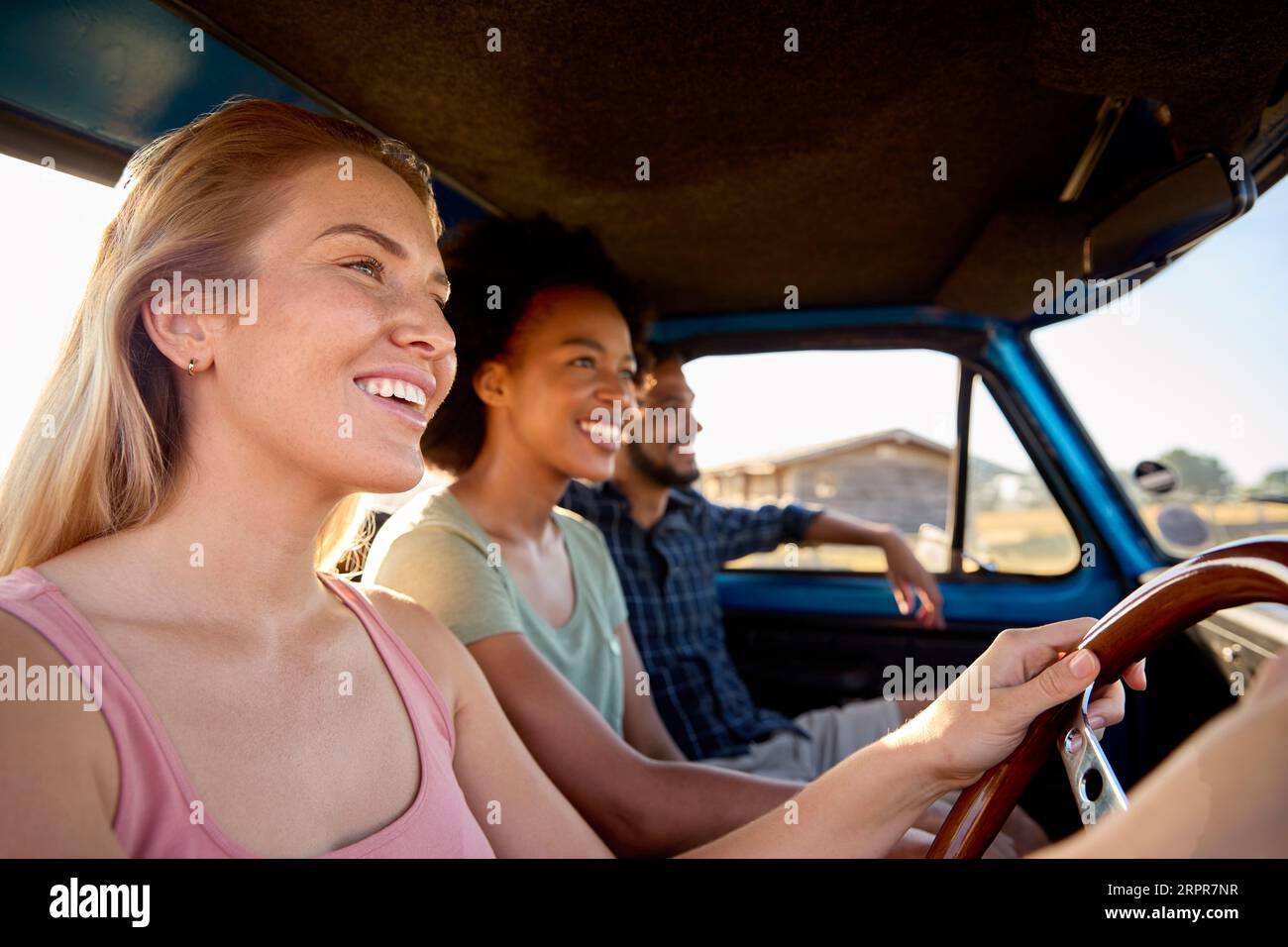 Group Of Friends On Road Trip Driving In Cab Of Pick Up Truck Stock ...
