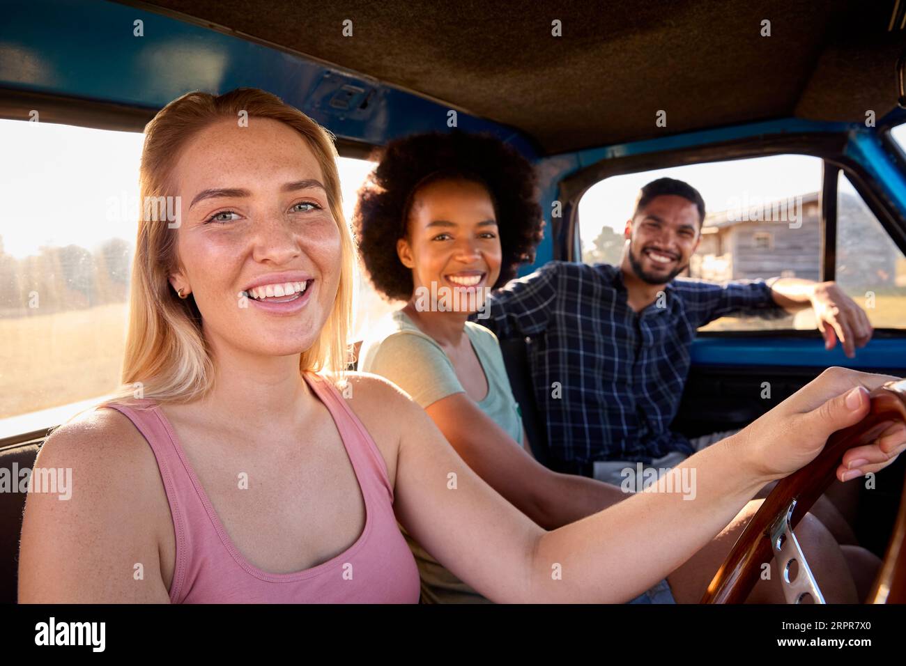 Portrait Of Group Of Friends On Road Trip Driving In Cab Of Pick Up ...