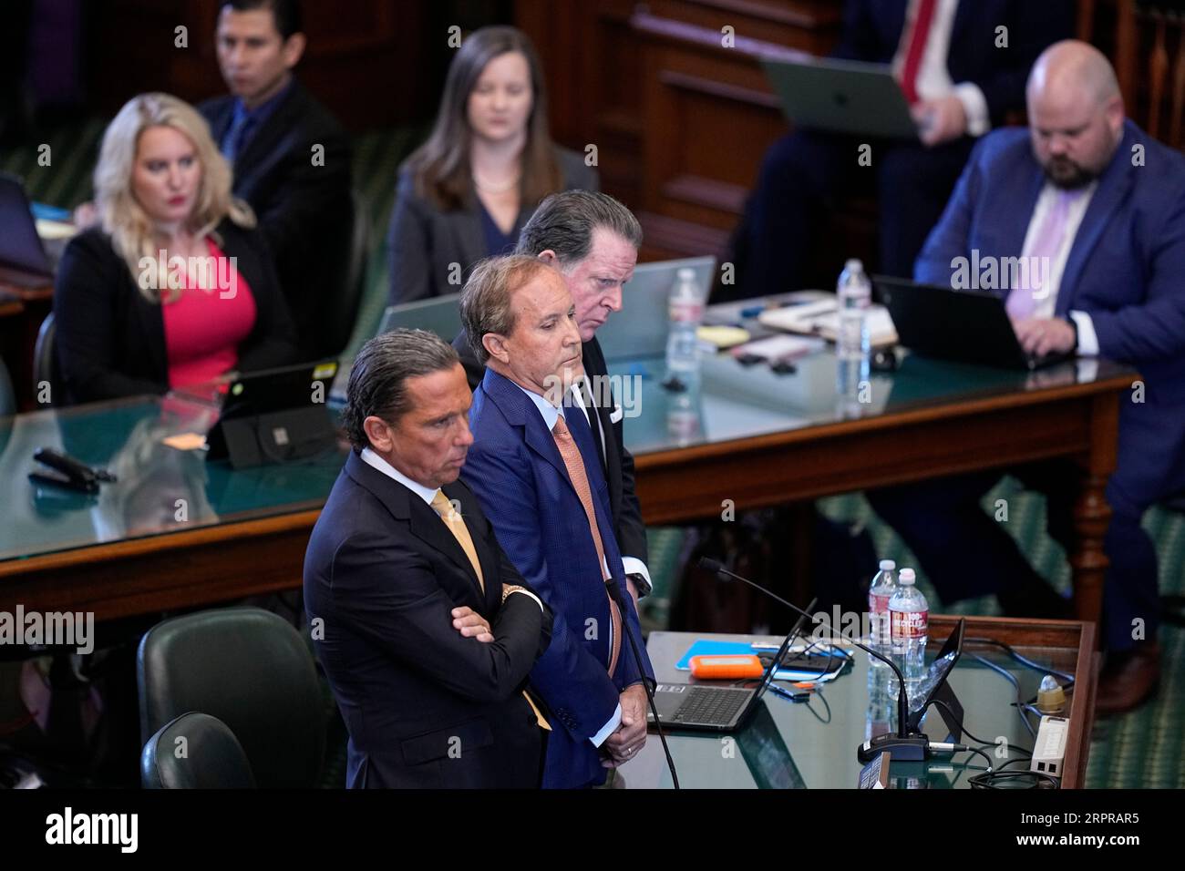 Texas state Attorney General Ken Paxton, center, stands between his ...