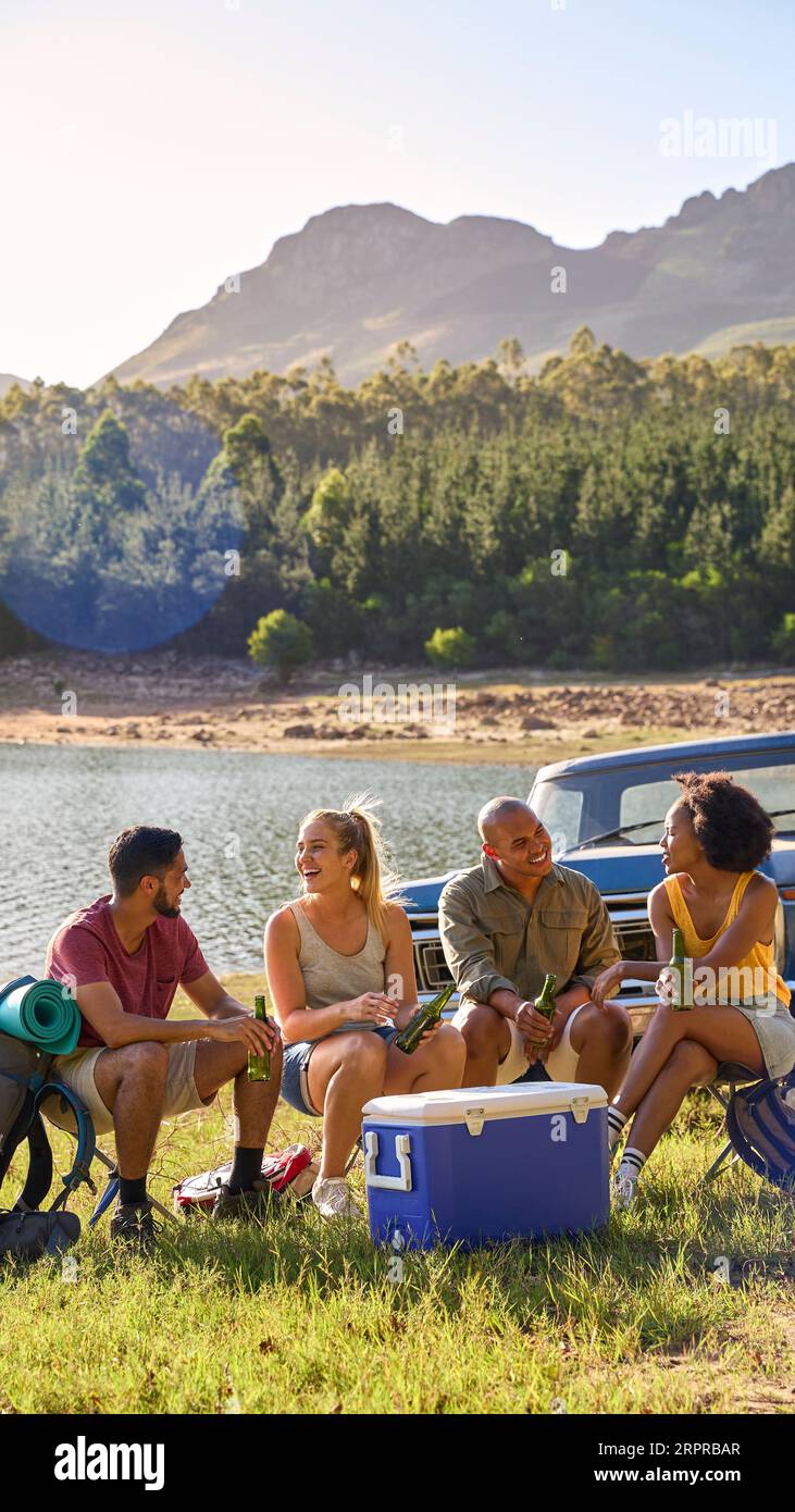 Group Of Friends With Backpacks By Pick Up Truck On Road Trip Drinking ...