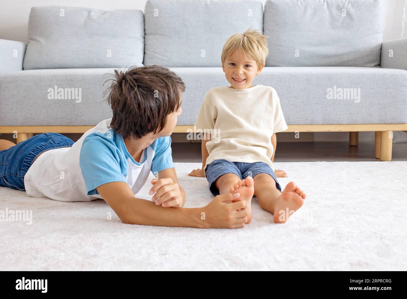 Happy positive children, tickling on the feet, having fun together, boy ...
