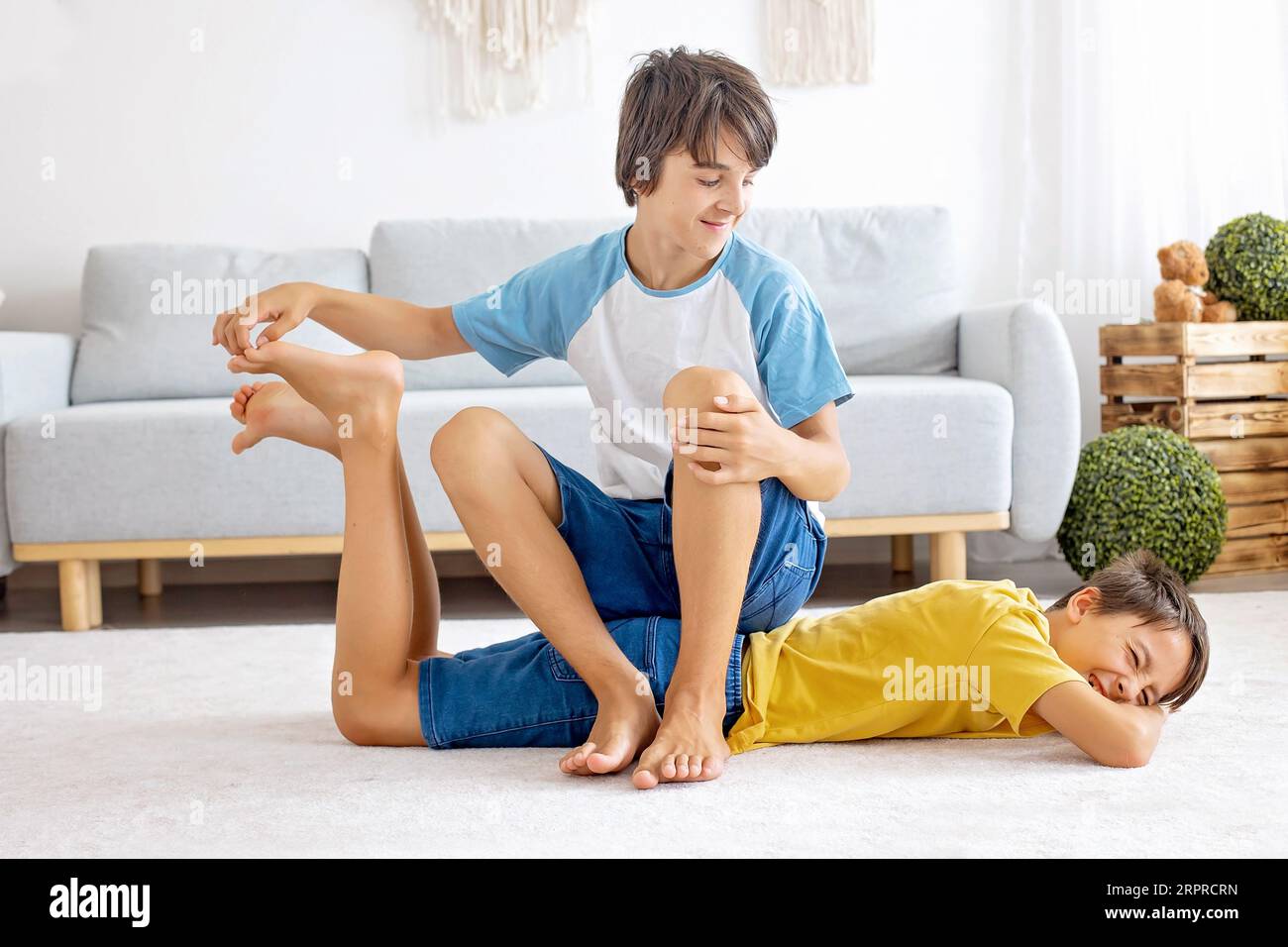 Happy positive children, tickling on the feet, having fun together, boy ...