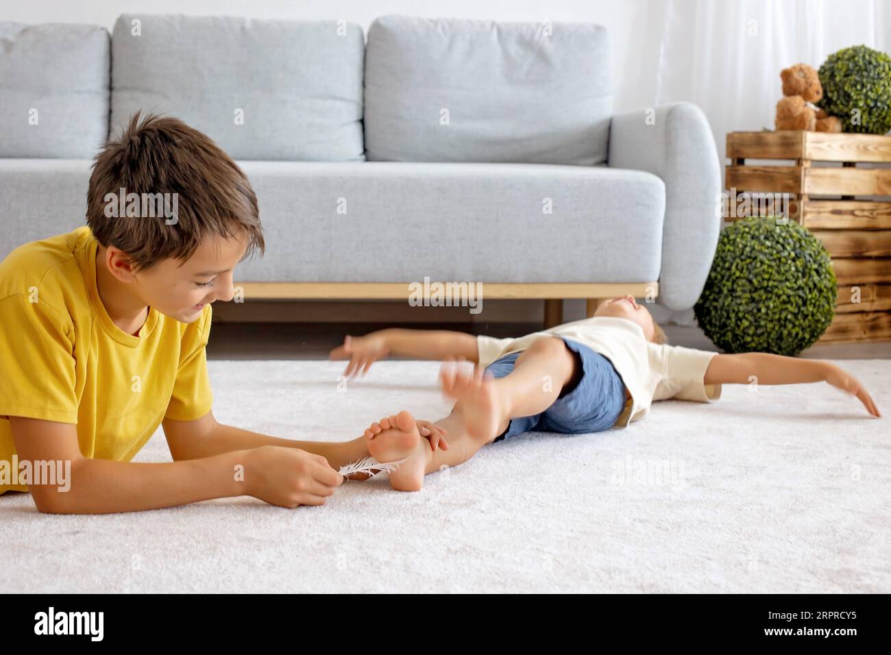 Happy positive children, tickling on the feet, having fun together, boy ...