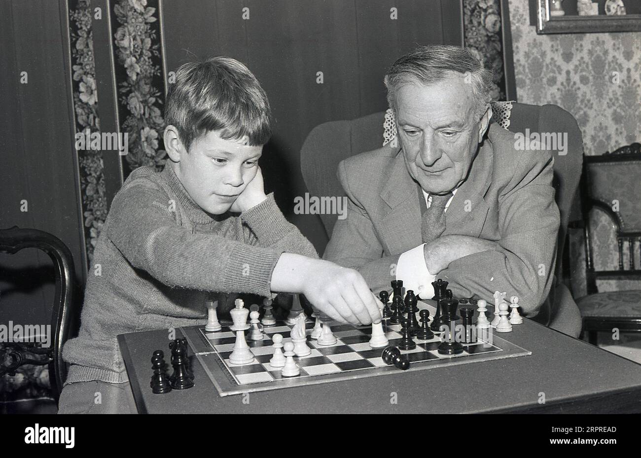 1980, sitting with his grandfather, a young boy playing a game of chess ...