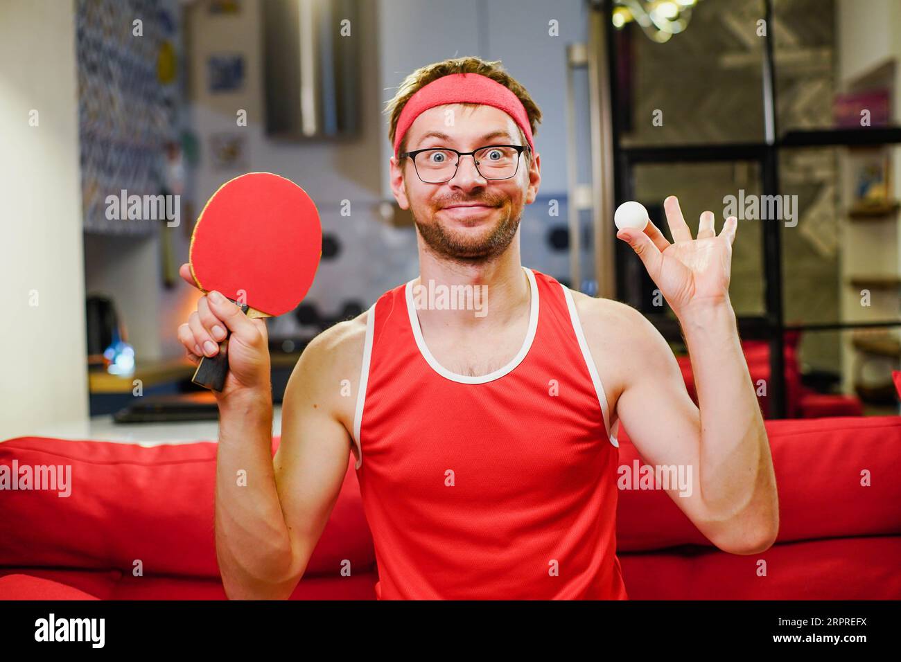 Funny crazy athlete nerd with ping pong table tennis racket and ball at ...