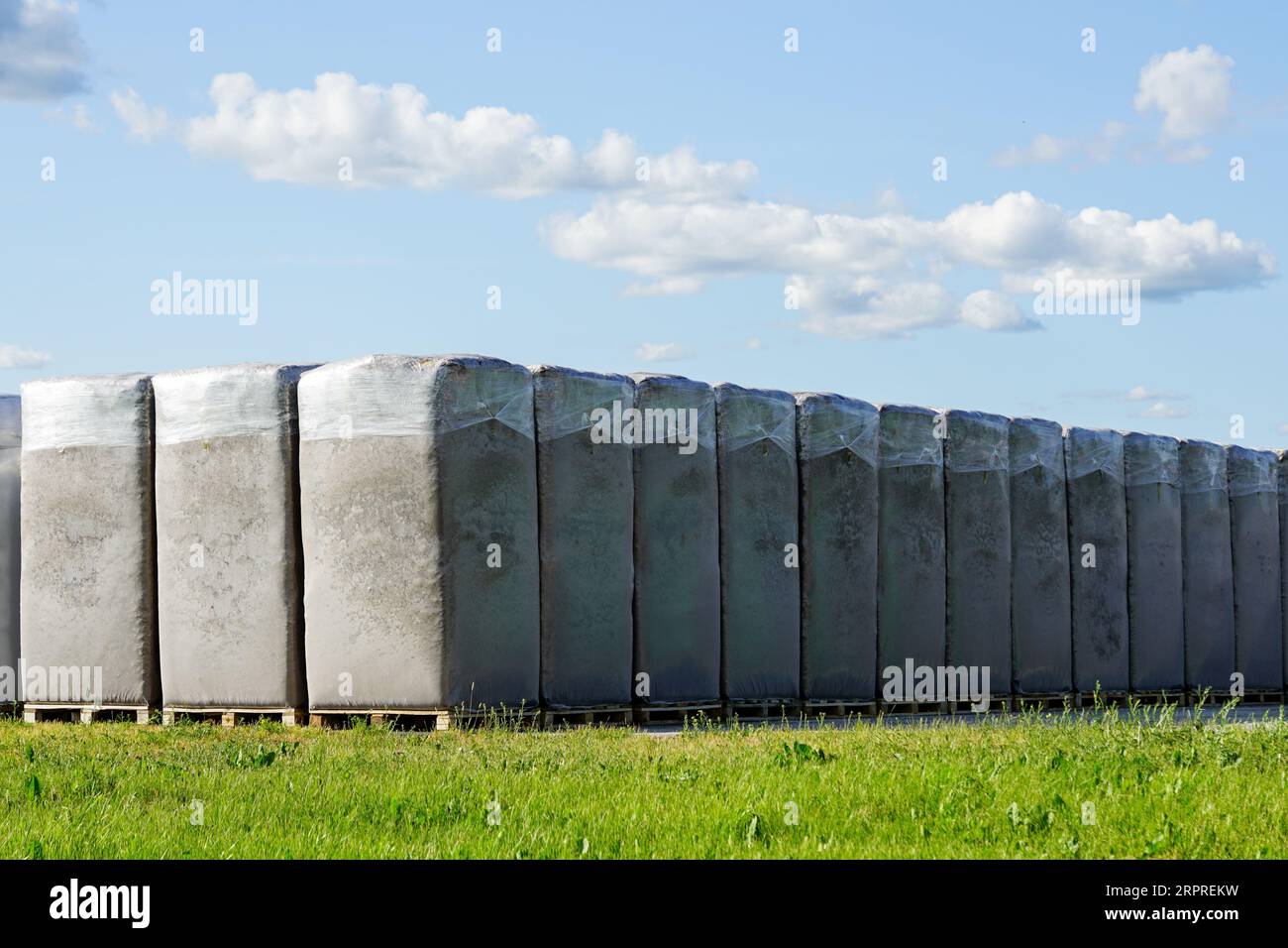 Peat extraction, many large polyethylene peat bags on wooden pallets on ...