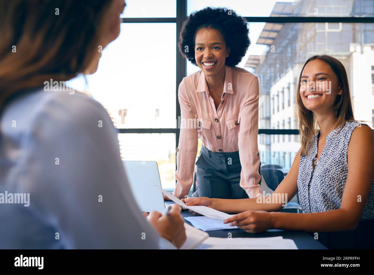 Female Multi-Cultural Business Team Meet Around Boardroom Table With ...