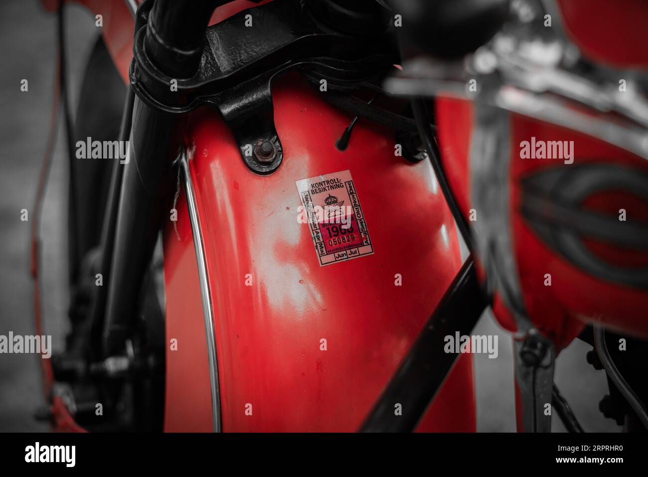 A close-up shot of a bright orange motorcycle with a tag or sticker ...