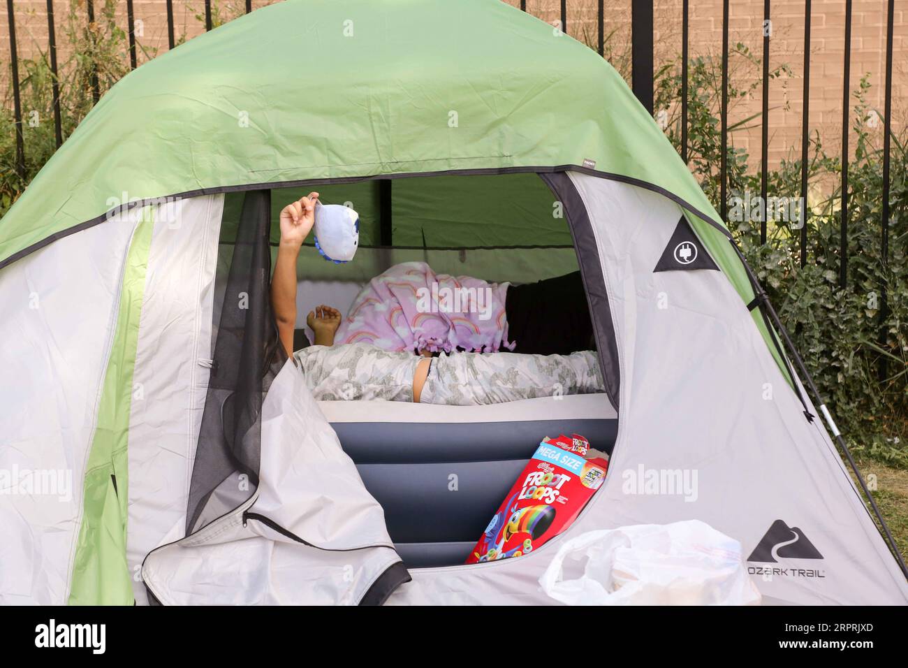 Asylum seekers take up temporary shelter in some green space adjacent ...