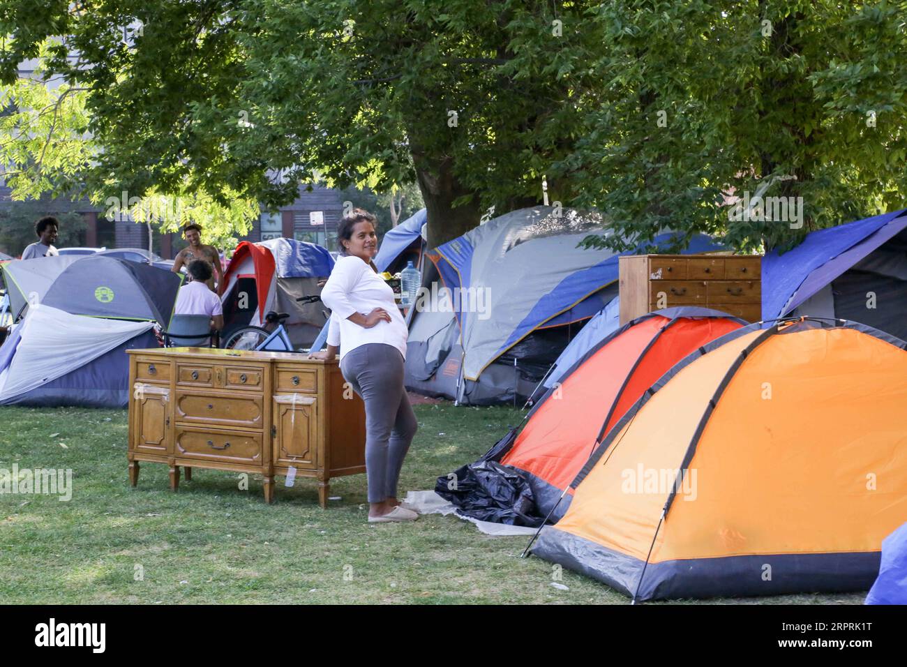Asylum seekers take up temporary shelter in some green space adjacent ...