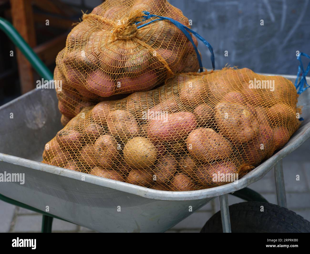 Large sacks of potatoes in a wheelbarrow. Close up Stock Photo - Alamy