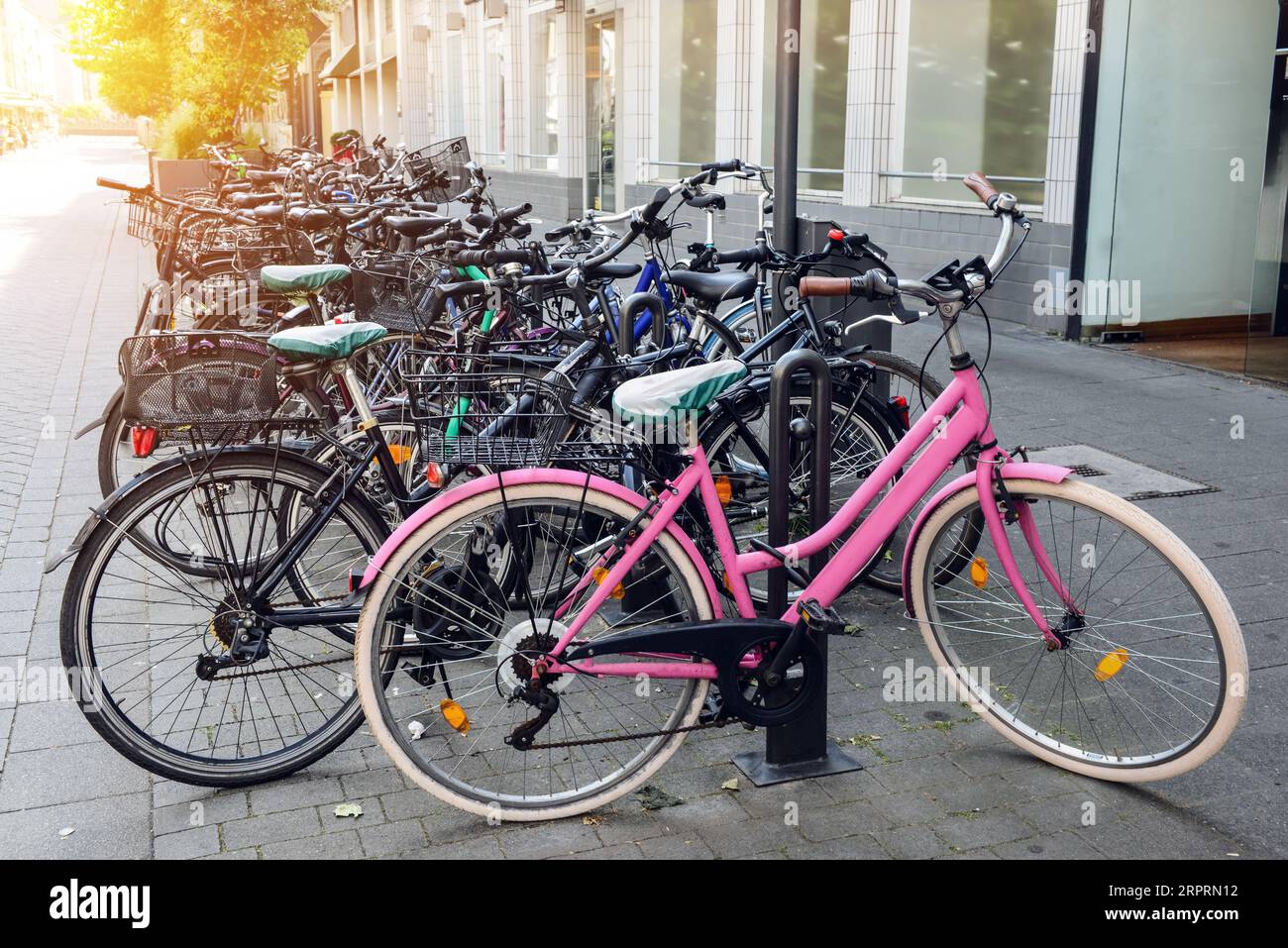 Modern bicycles parked on city street Stock Photo - Alamy