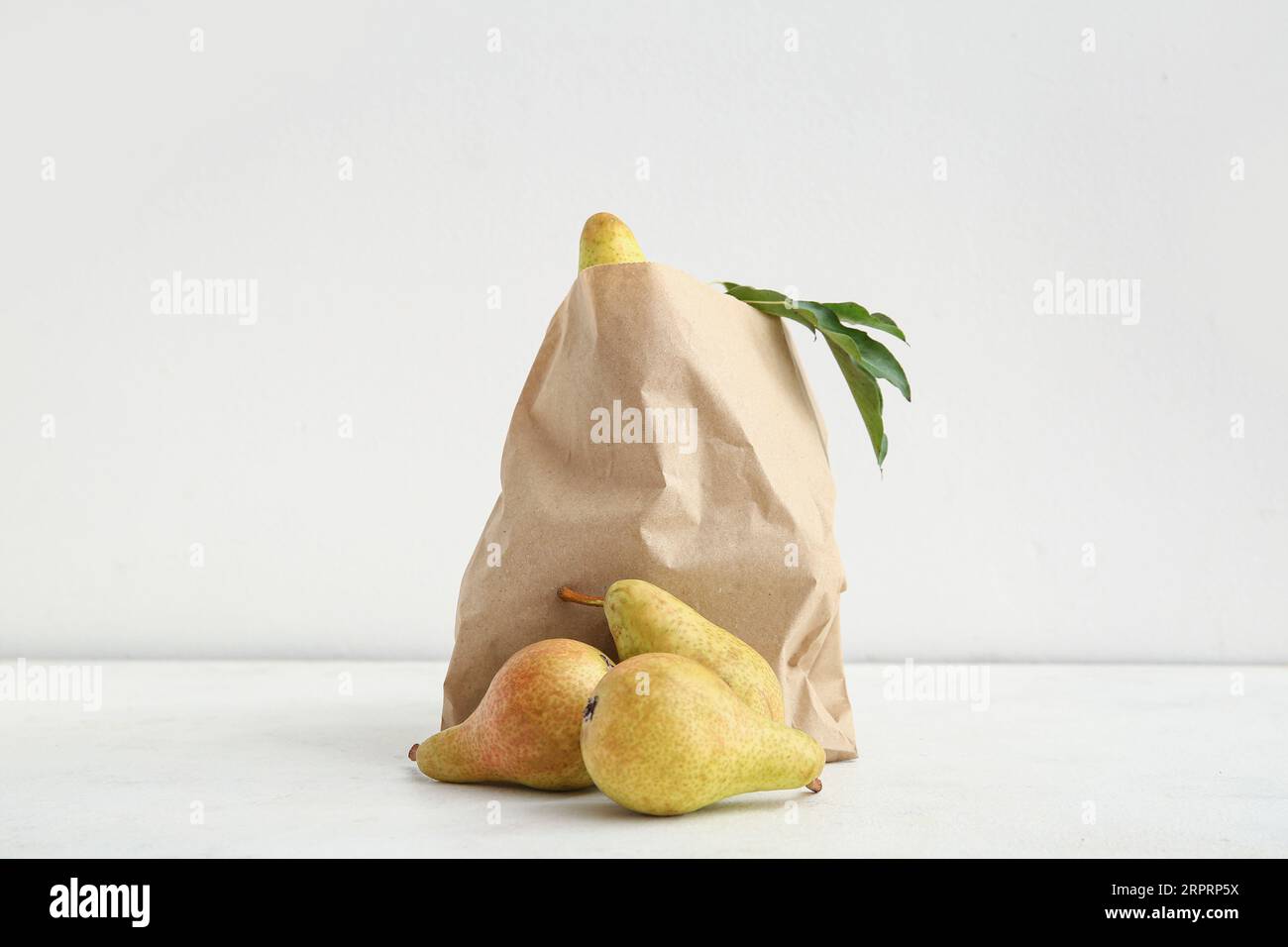 Paper bag with ripe pears on white background Stock Photo - Alamy