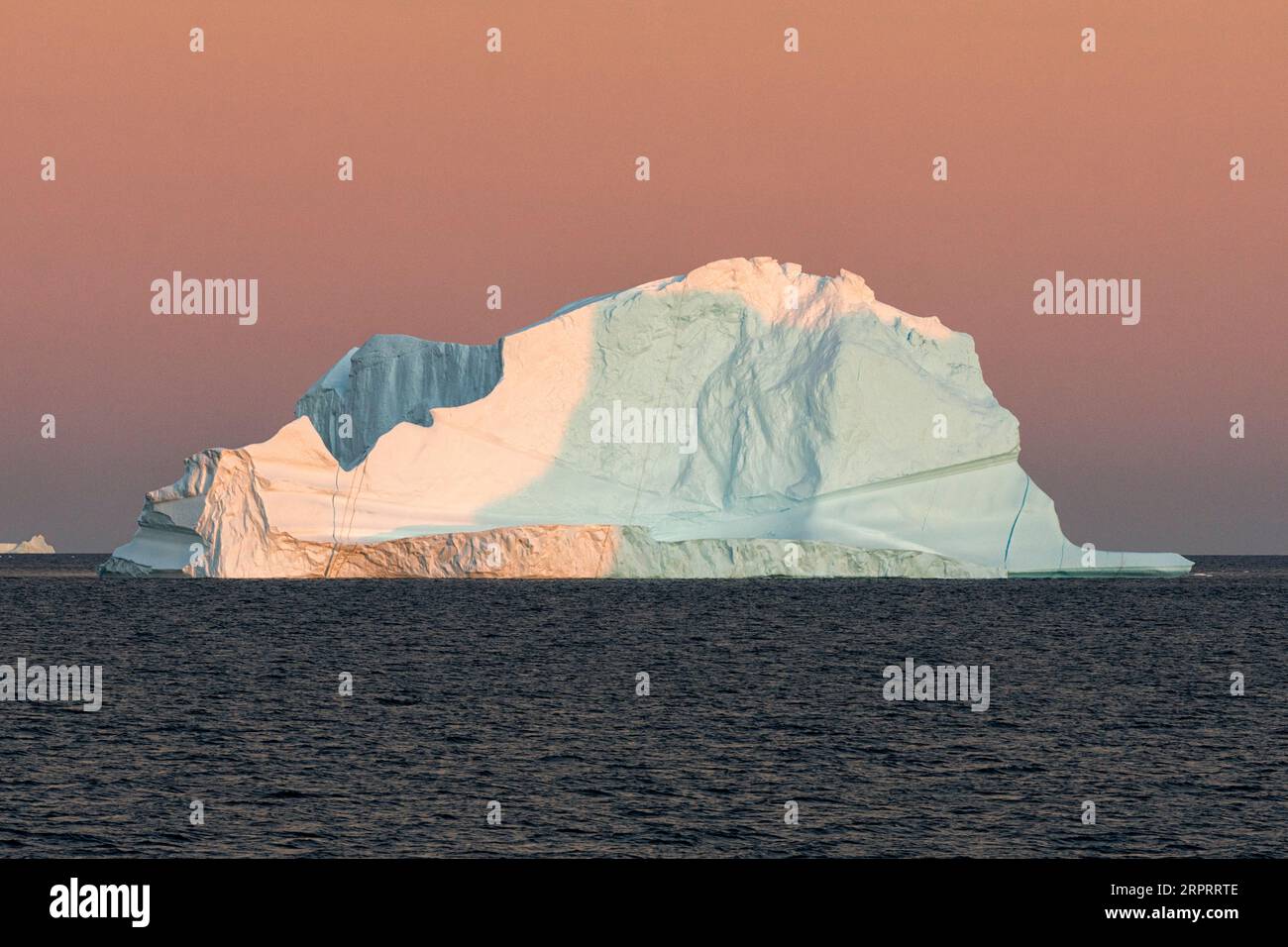 Huge floating iceberg in Disko Bay in the arctic early morning twilight ...