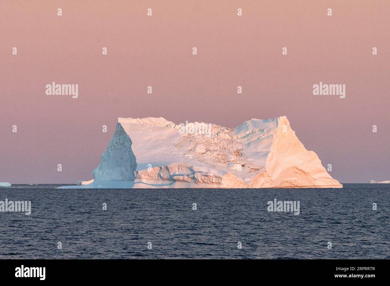 Huge floating iceberg in Disko Bay in the arctic early morning twilight ...