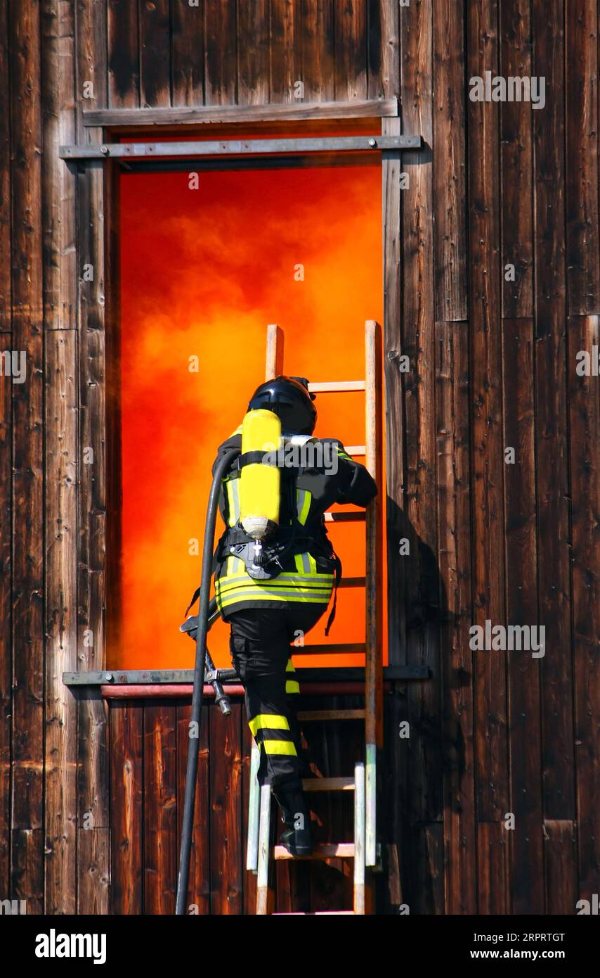 firefighter enters through a window with an oxygen tank during fire ...