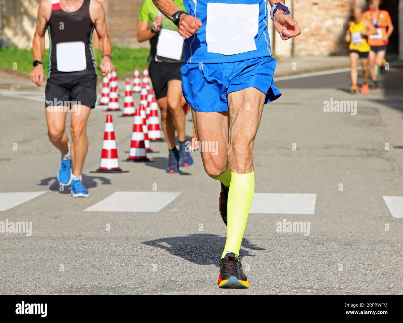 athletic Runners running very fast during marathon in the asphalt road ...
