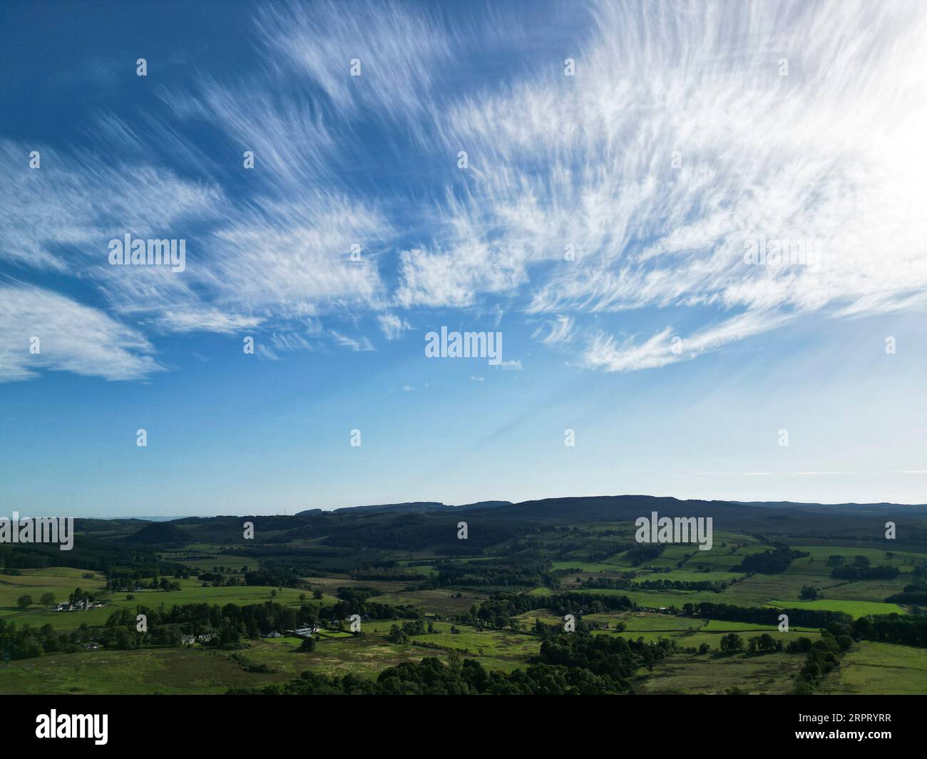 Example of cirrus cloud over green landscape Stock Photo - Alamy
