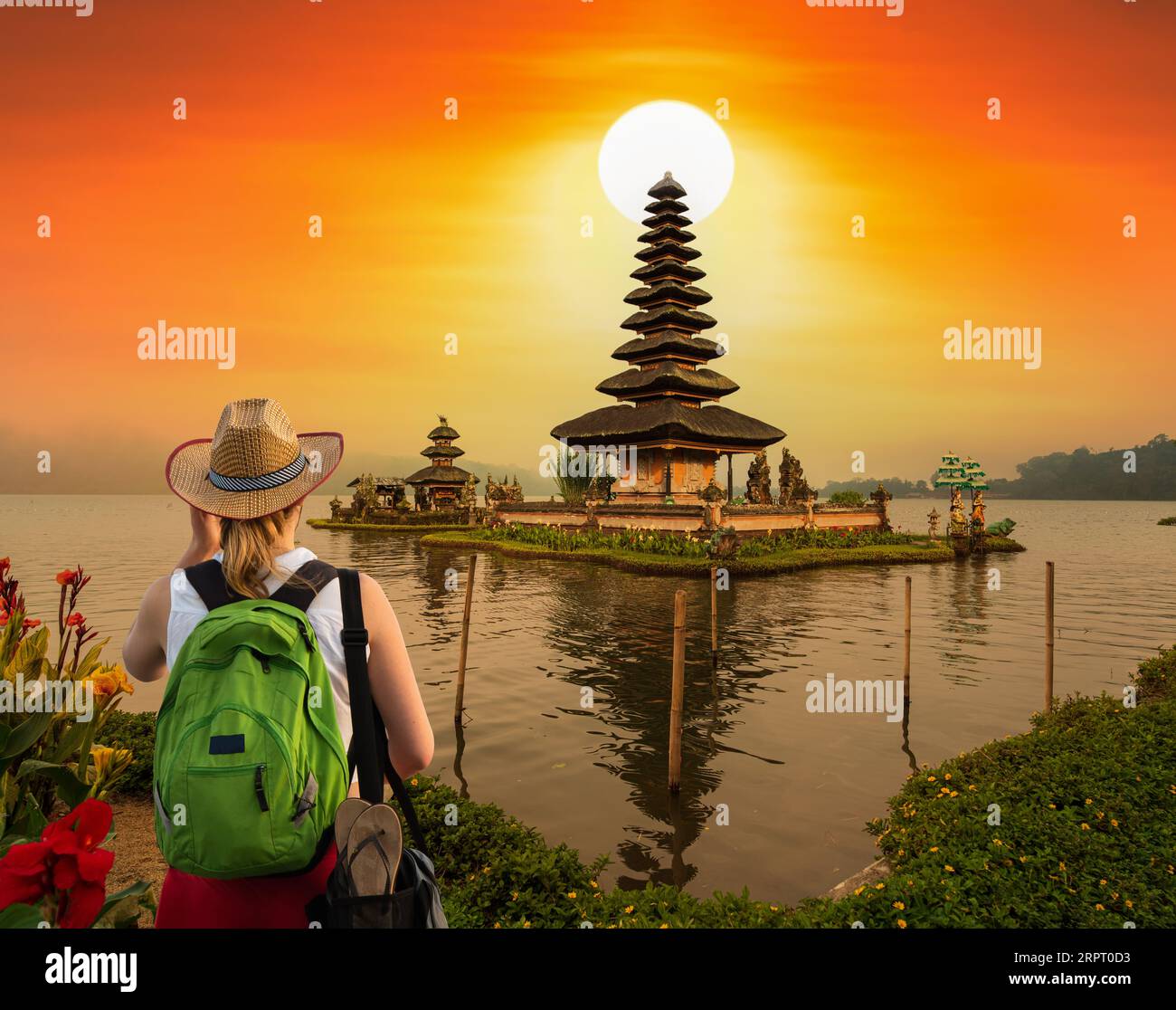 Tourist woman watching the sunrise at the temple of Pura Ulun Danu ...