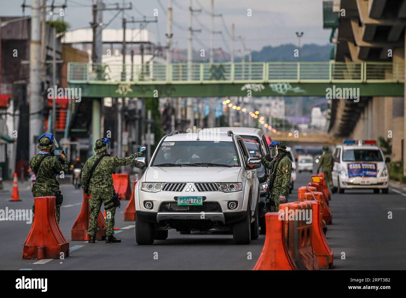 200410 -- ANTIPOLO CITY, April 10, 2020 -- Police check the temperature ...