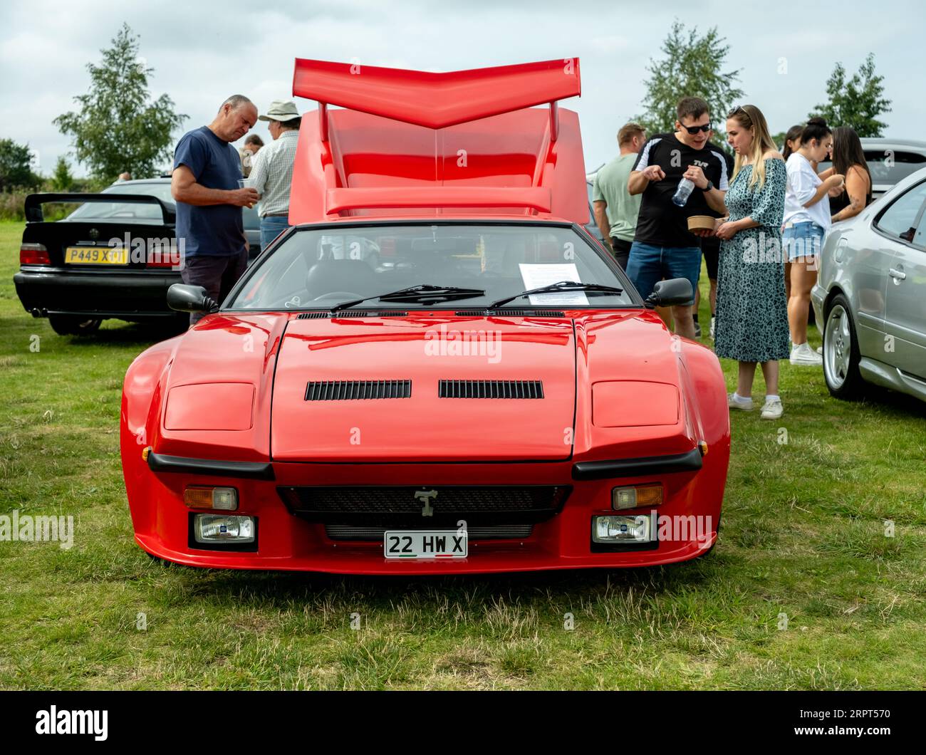 Front on view of a red super car on display at an outdoor car show in ...
