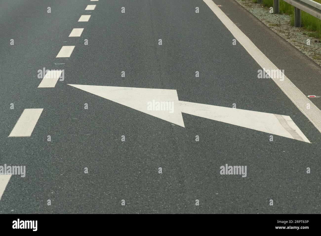 The white arrow on the pavement points to the left, the road narrows ...