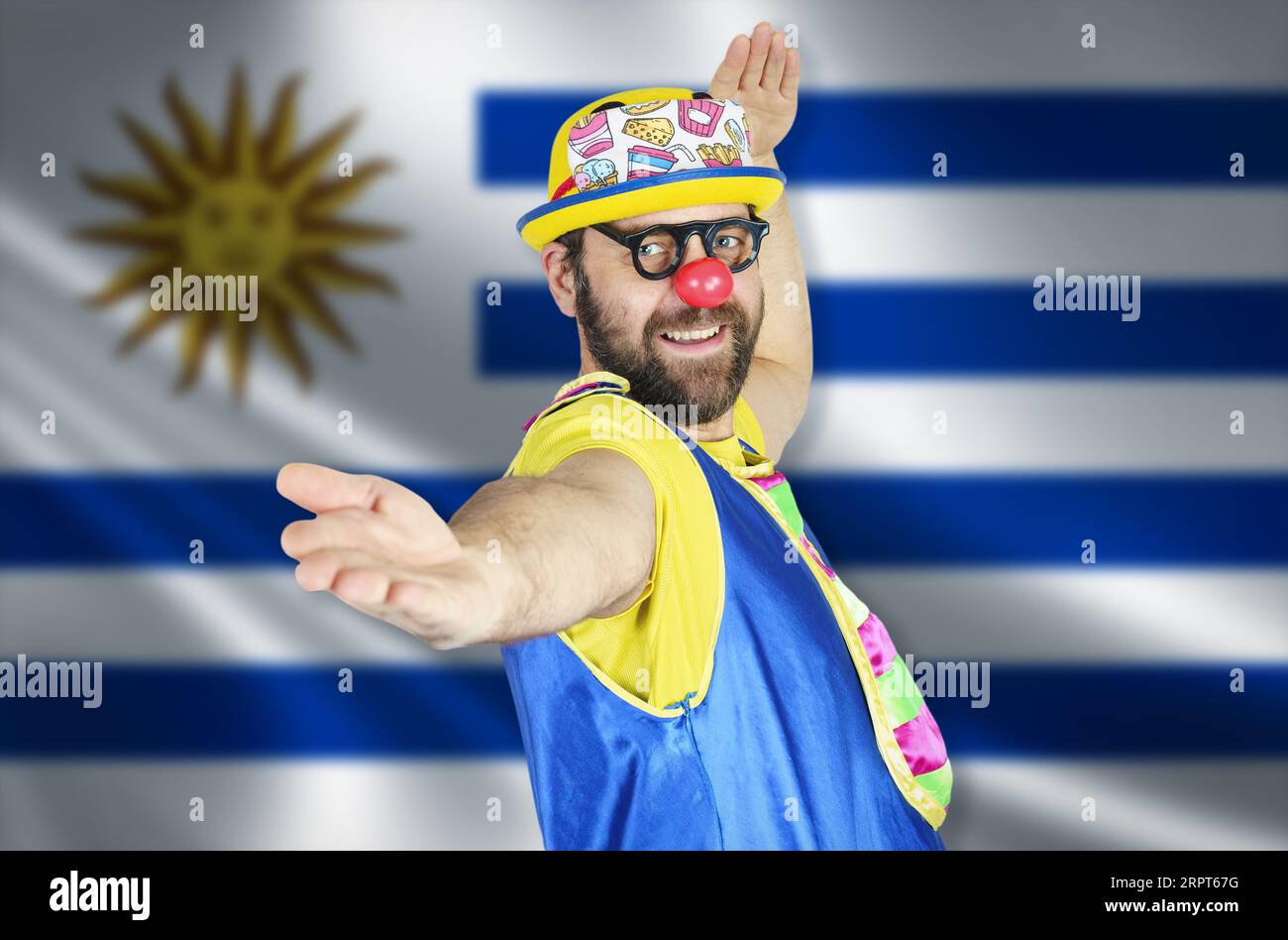 A cheerful clown stands in a welcoming pose against the background of ...