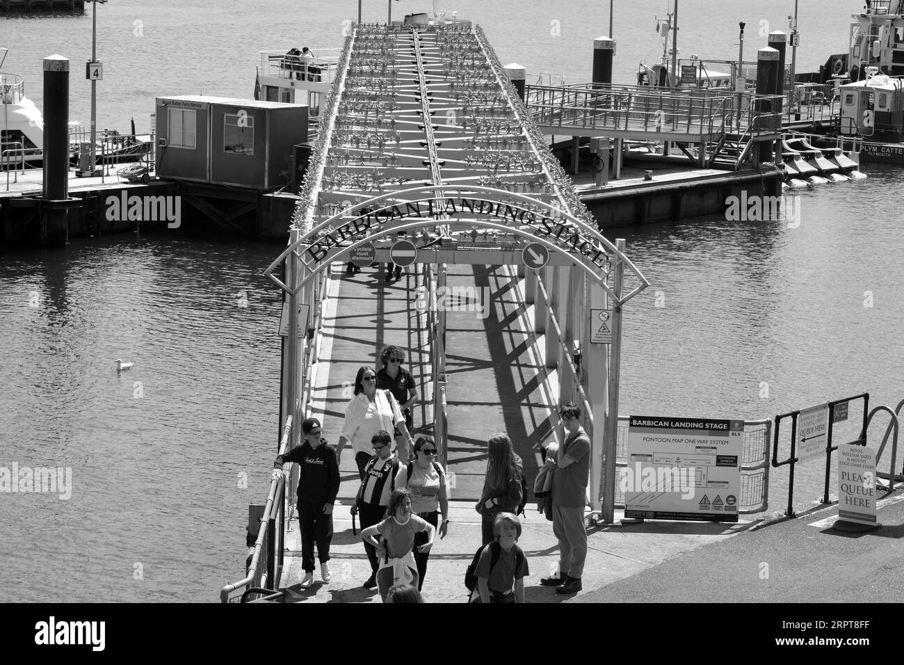 Tourists disembark via a narrow steel bridge after enjoying a boat trip ...