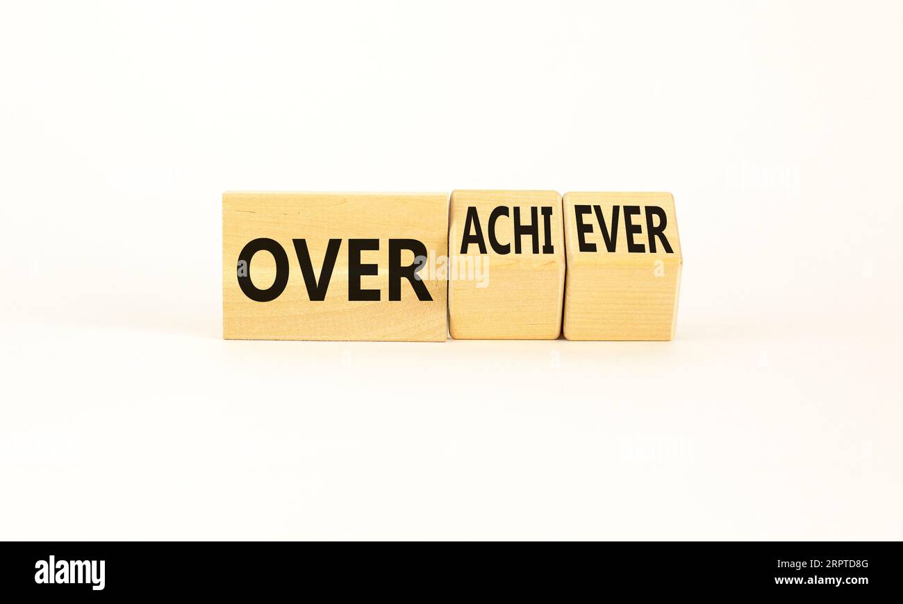Achiever or overachiever symbol. Businessman turns wooden cubes and ...