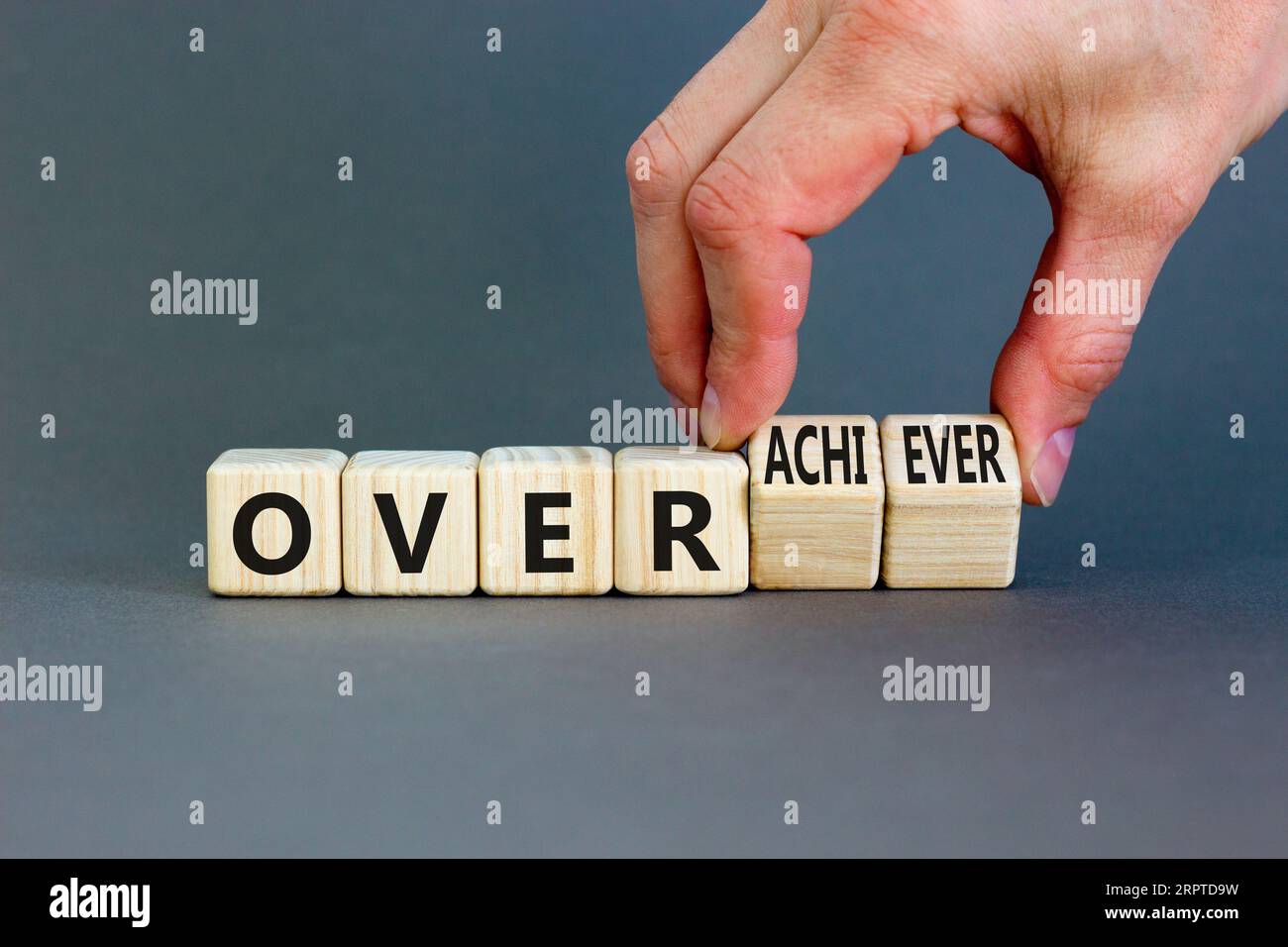Achiever or overachiever symbol. Businessman turns wooden cubes and ...