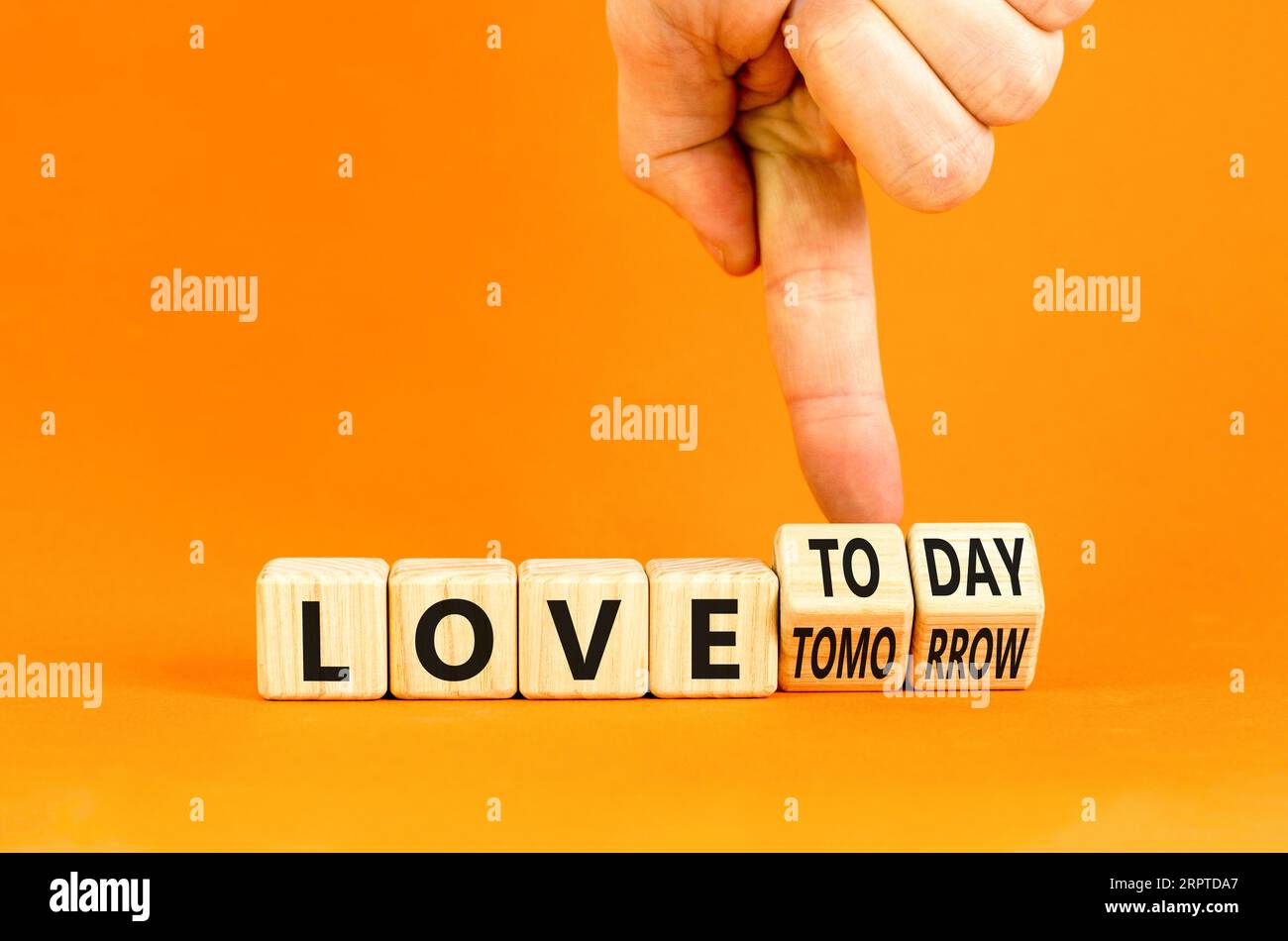 Love today not tomorrow symbol. Businessman turns wooden cubes and ...