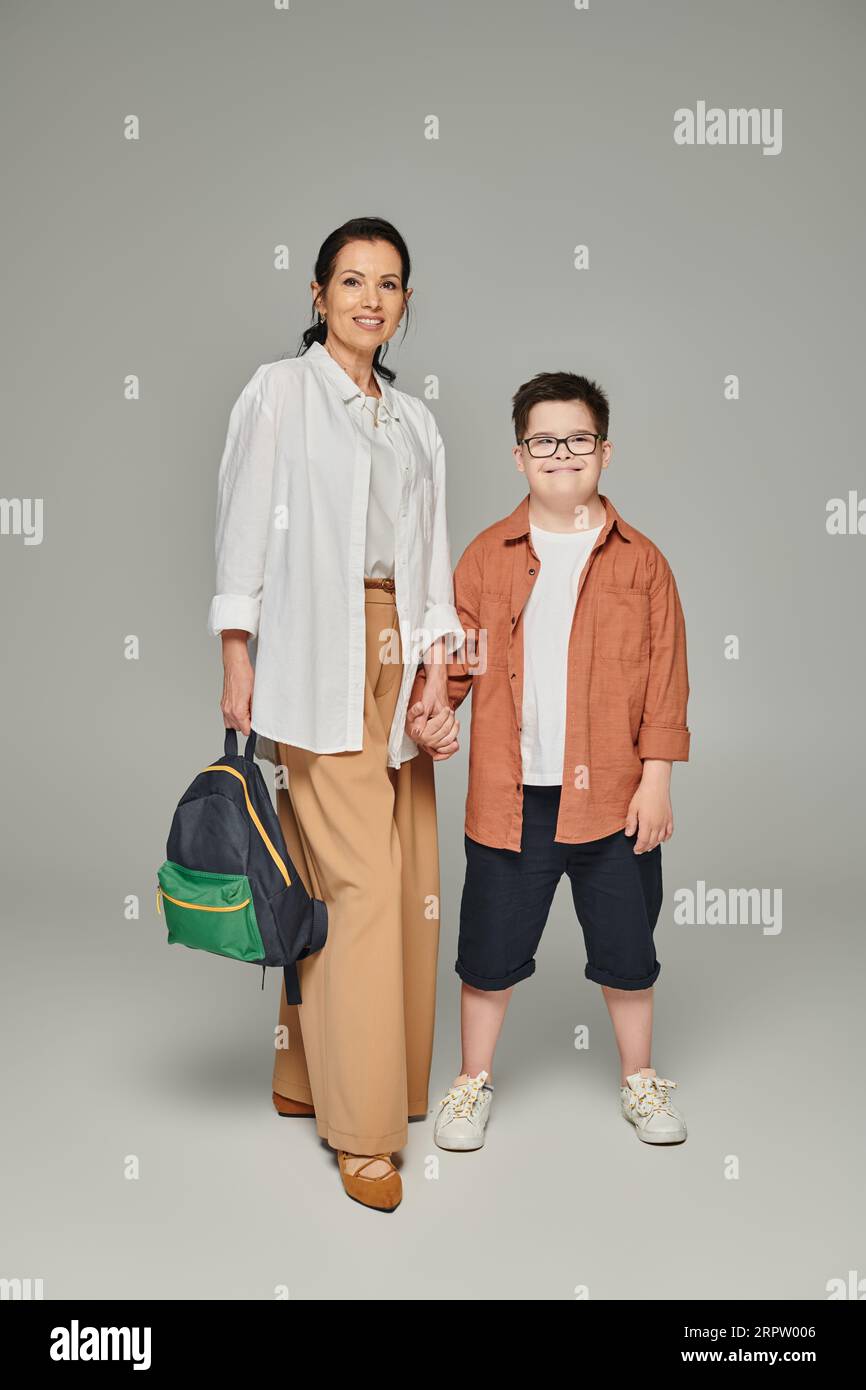 middle aged woman with school backpack and son with down syndrome ...
