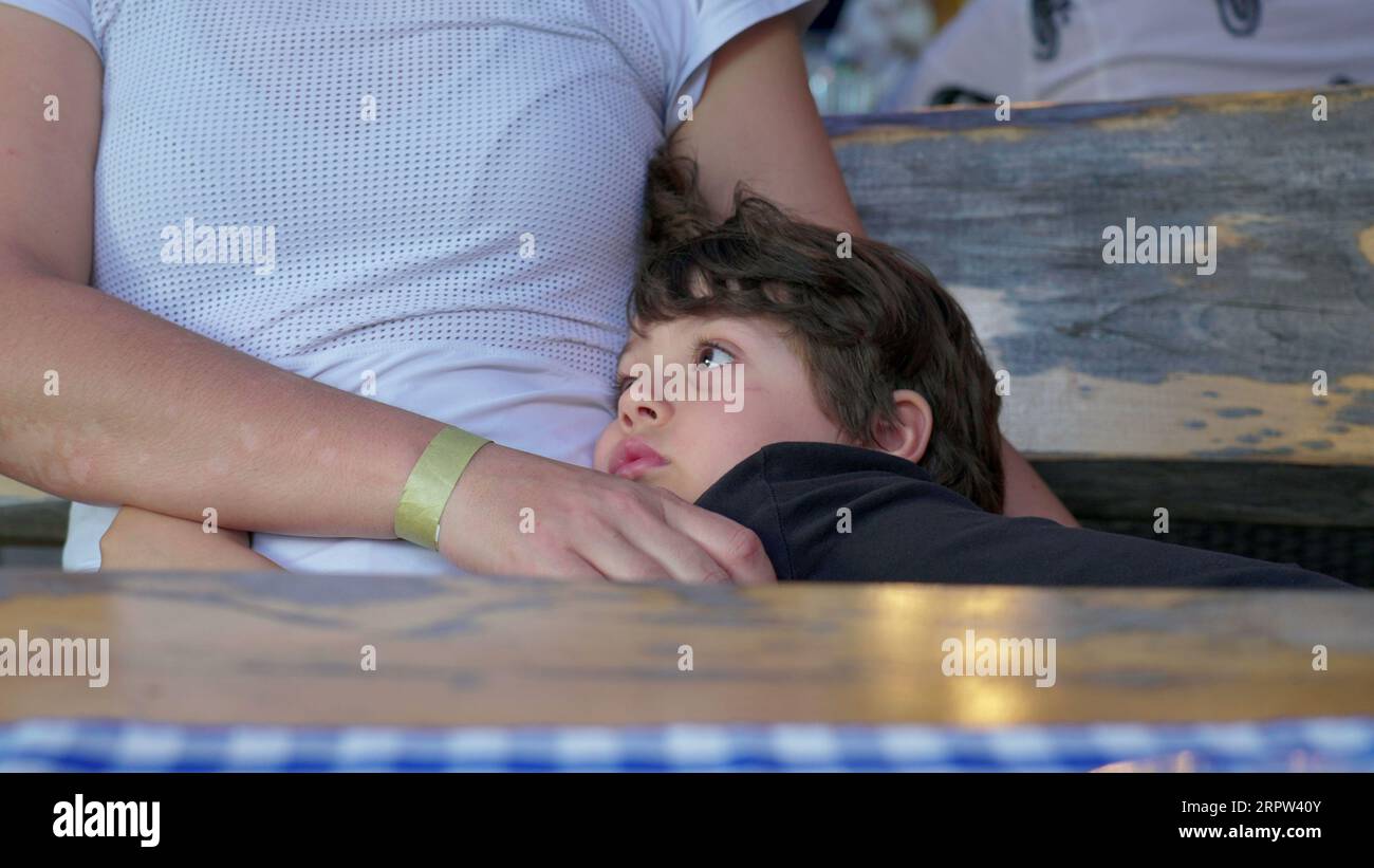 Bored little boy clinging to mother's body with nothing to do, child ...