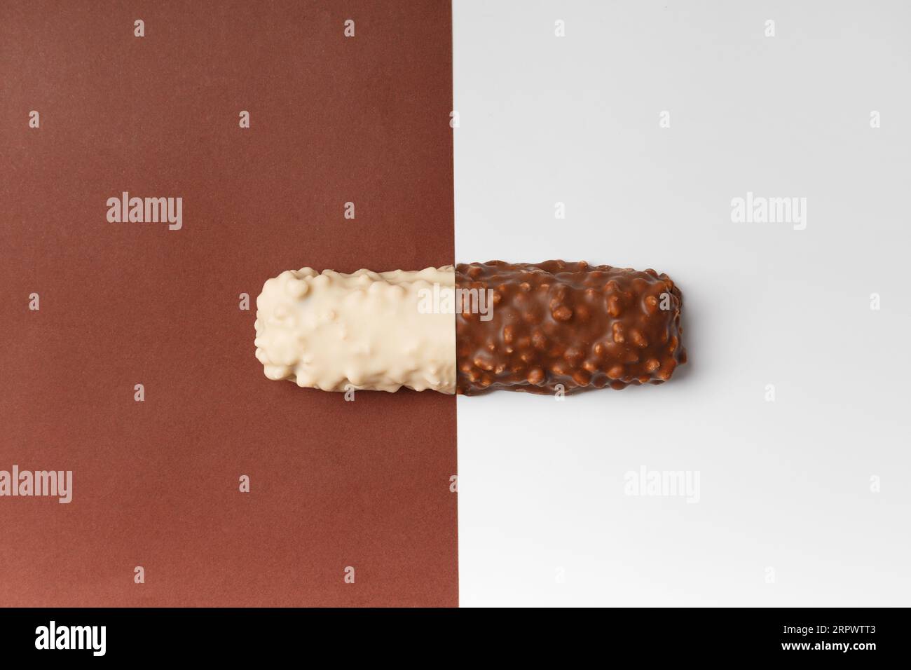 White and milk chocolate on contrasting backgrounds. Two halves of a ...