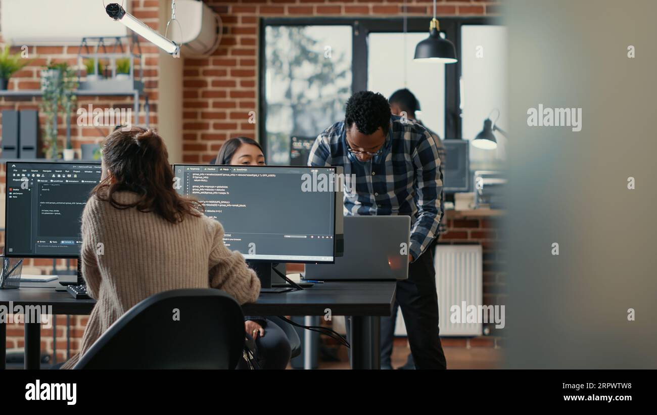 Database programer writing code in front of multiple computer screens ... Database programer writing code in front of multiple computer screens ...