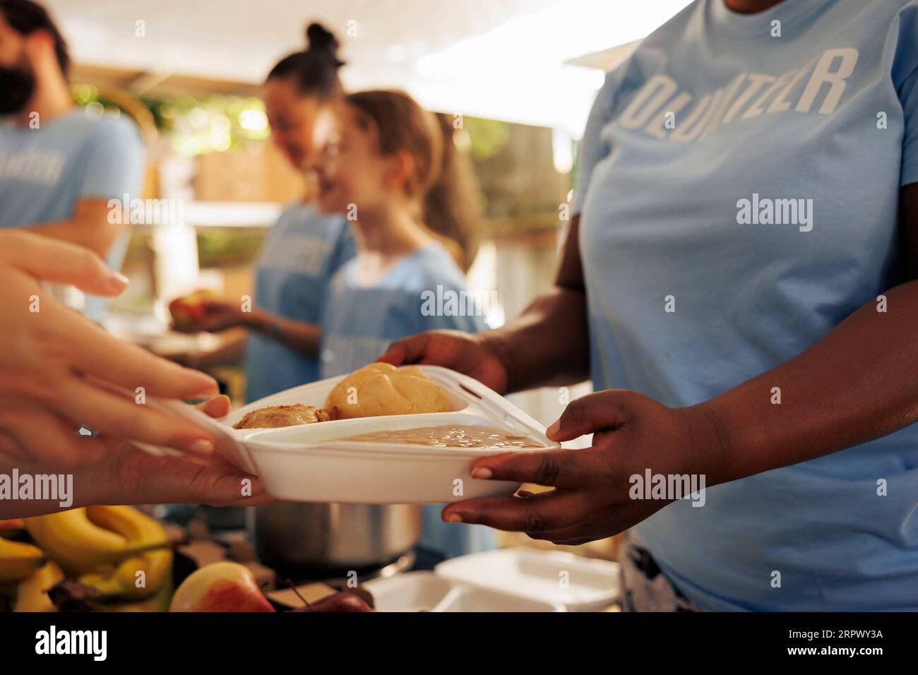 Close-up of a young black woman hands distributing fresh produce to ...