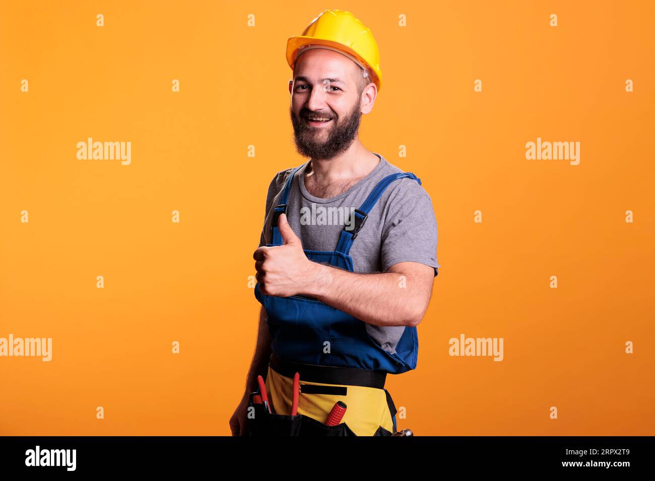 Young building contractor giving thumbs up on camera, showing like and ...