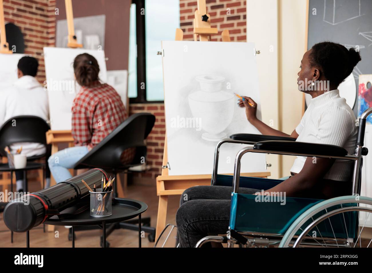 Disabled African American girl in wheelchair drawing on canvas during ...